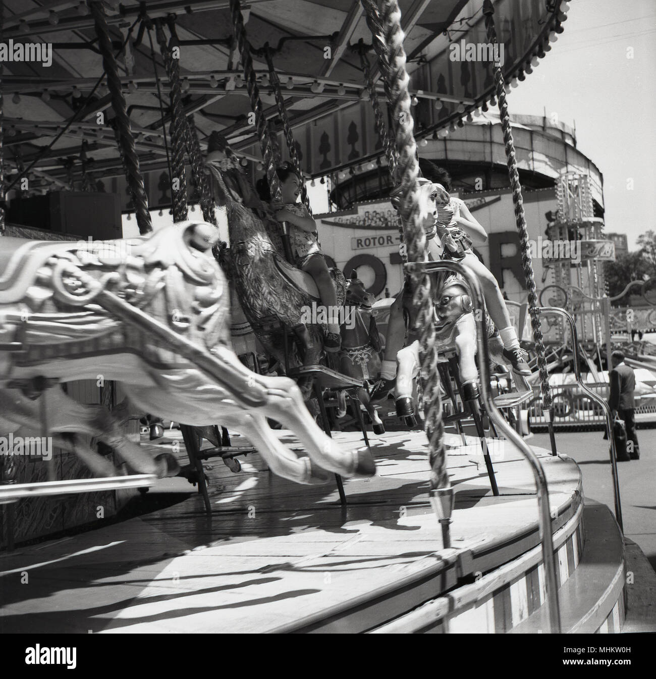 1960s, historical, children enjoying a ride on wooden horses on a ...