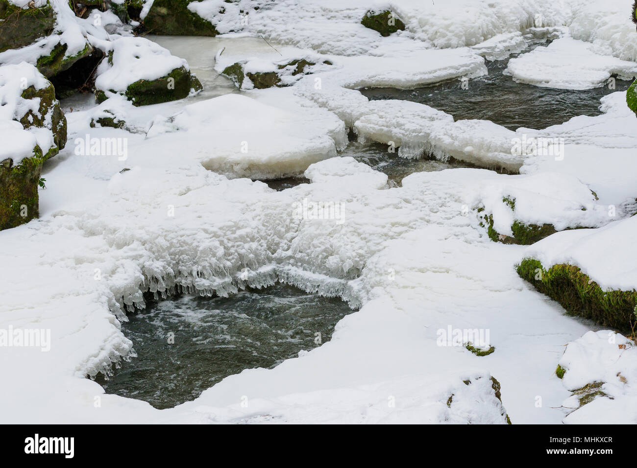 Little cascade with ice and icicles Stock Photo - Alamy