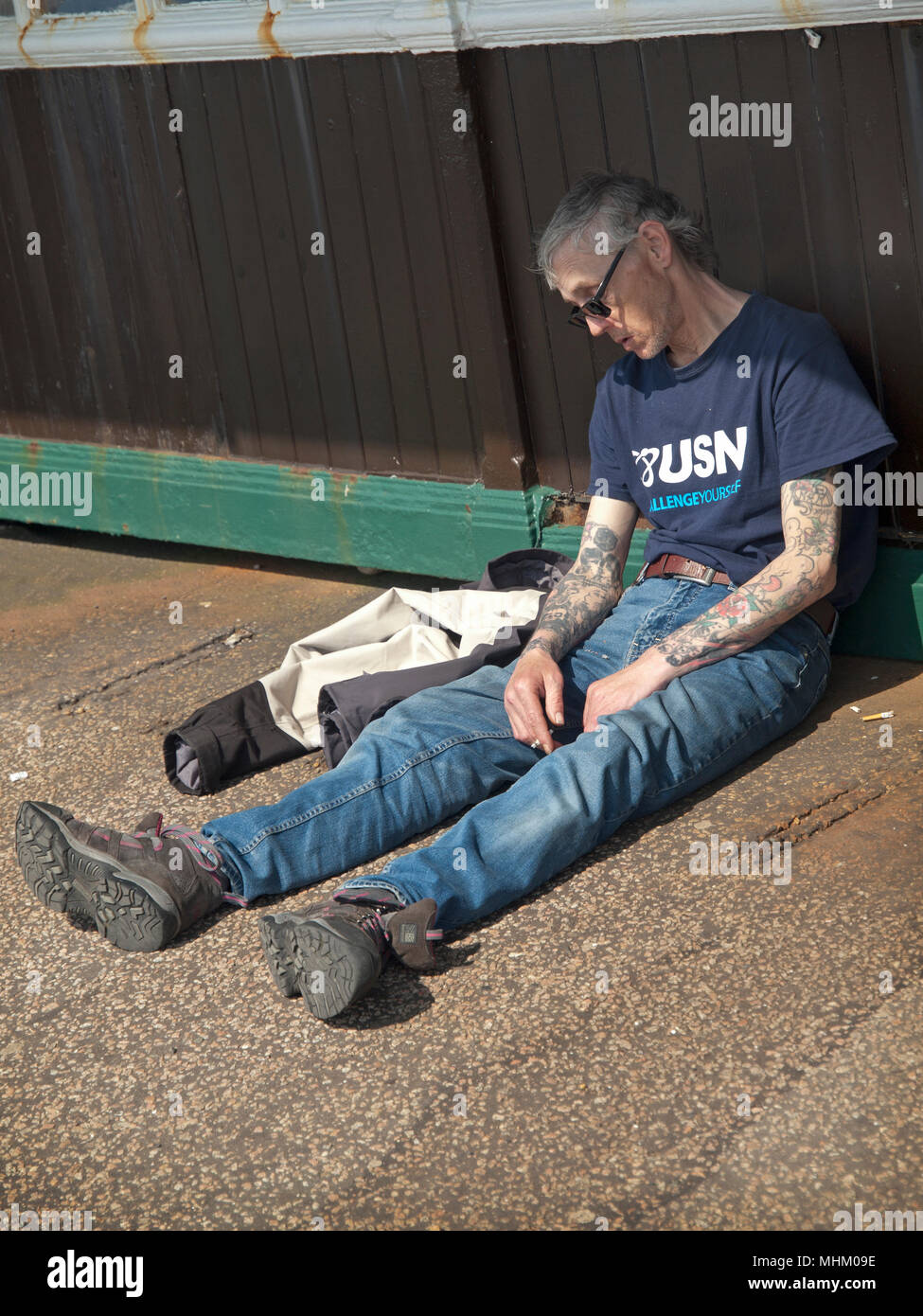 A man who has passed out on the Brighton seafront Stock Photo - Alamy