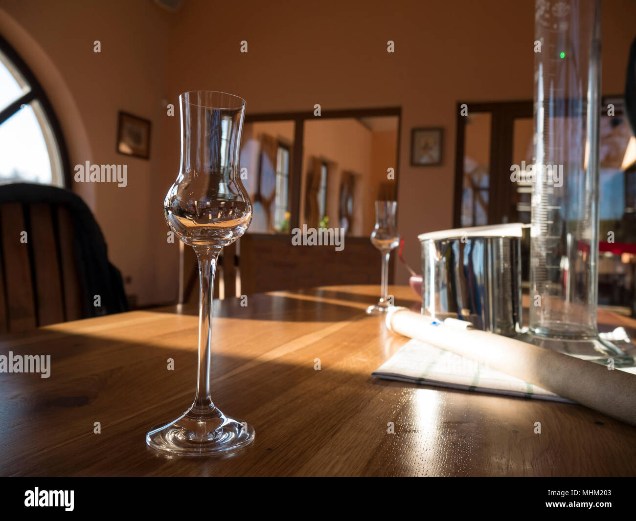 empty alcohol glass on wooden table during destilation of spirits ...