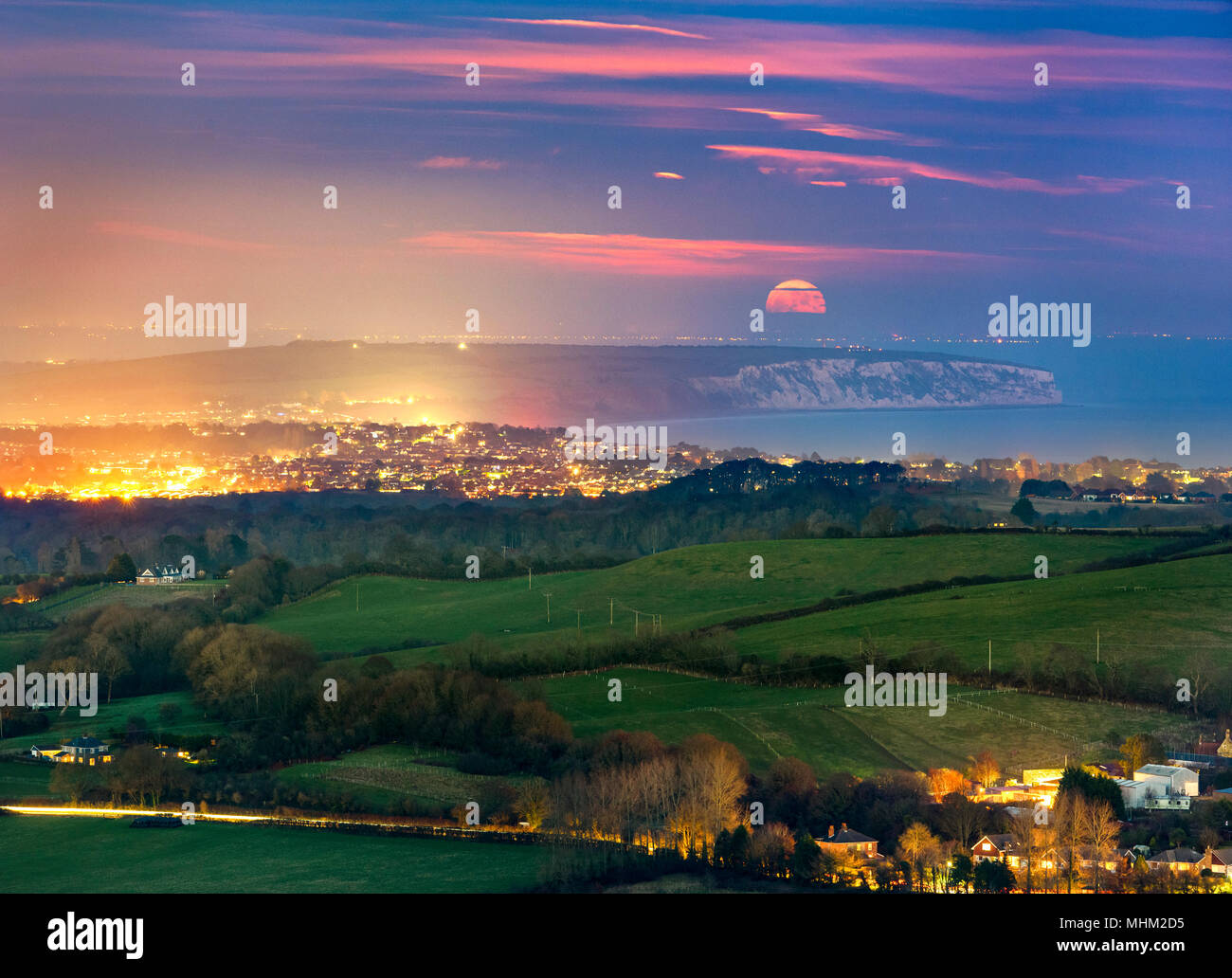 Moonrise over the sea and land at the coast Stock Photo - Alamy