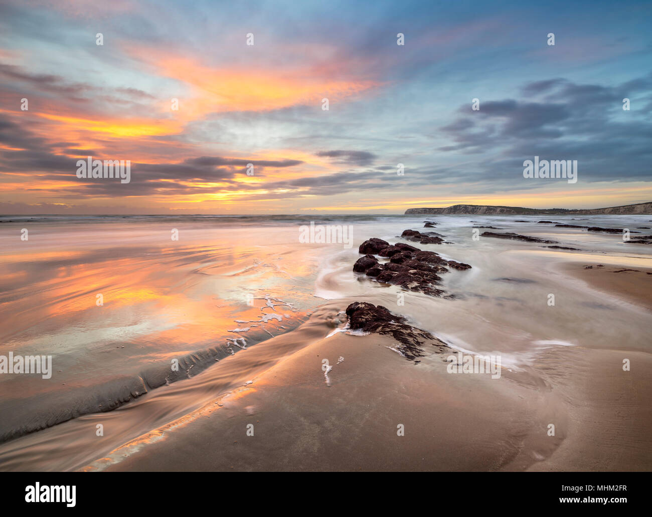 Seascape sunset, with rocks and headland at Compton Stock Photo - Alamy