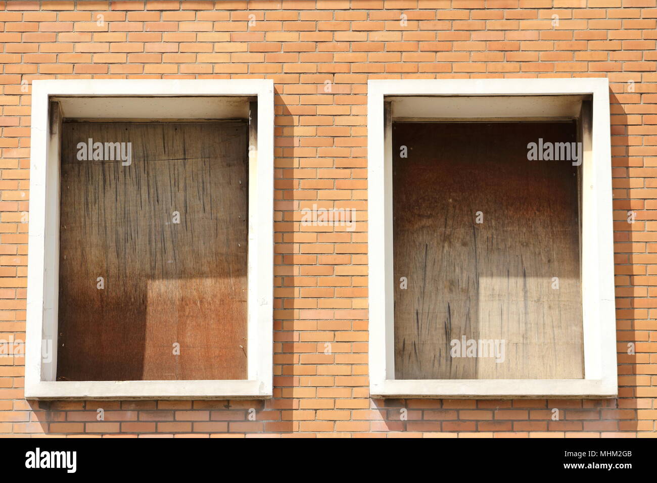 old windows with wood panels that need a renovation on a brick house ...