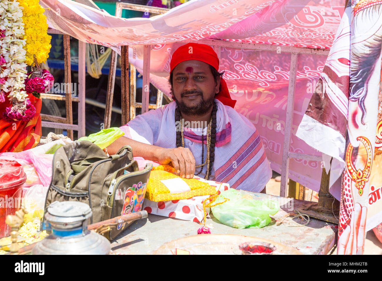 Unidentified brahman man with statues of the Indian gods and offerings ...