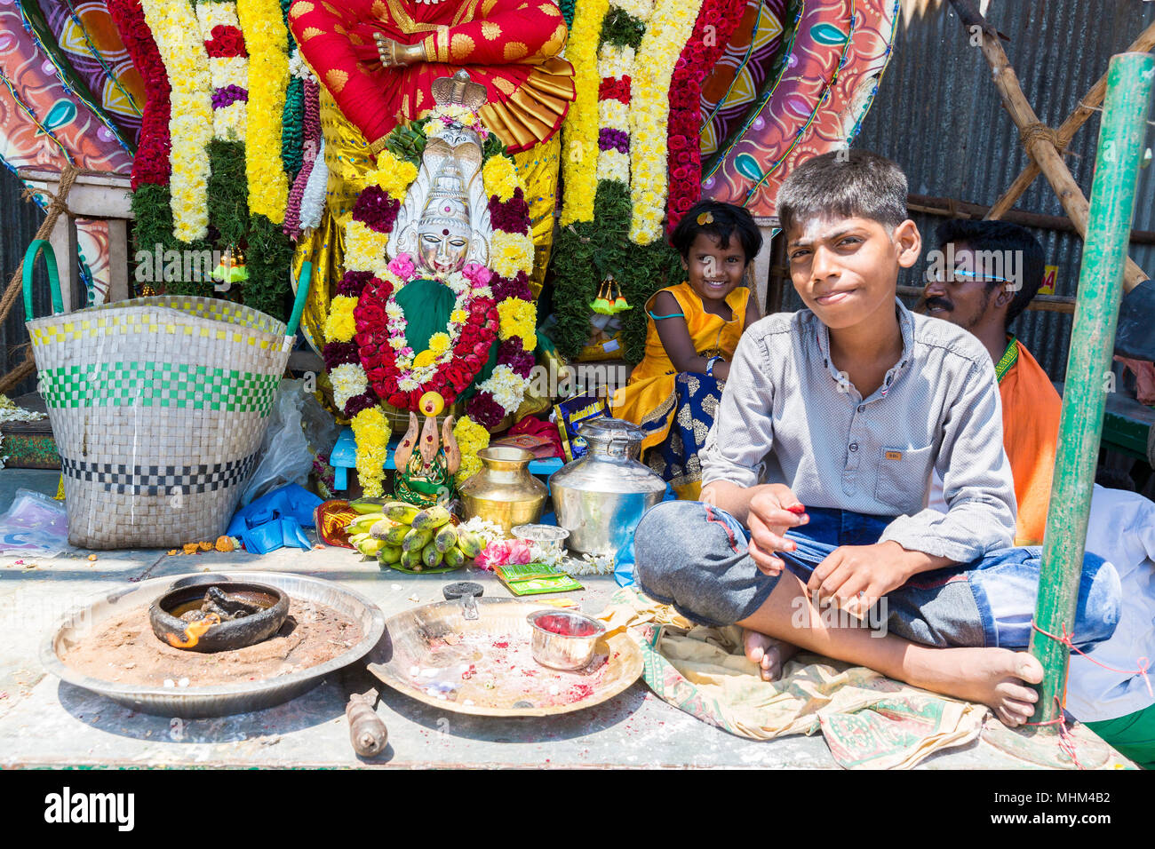 Unidentified brahman man with statues of the Indian gods and offerings ...