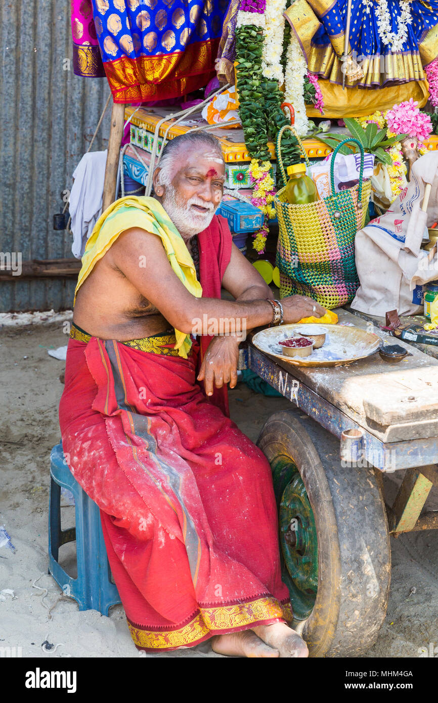 Unidentified brahman man with statues of the Indian gods and offerings ...