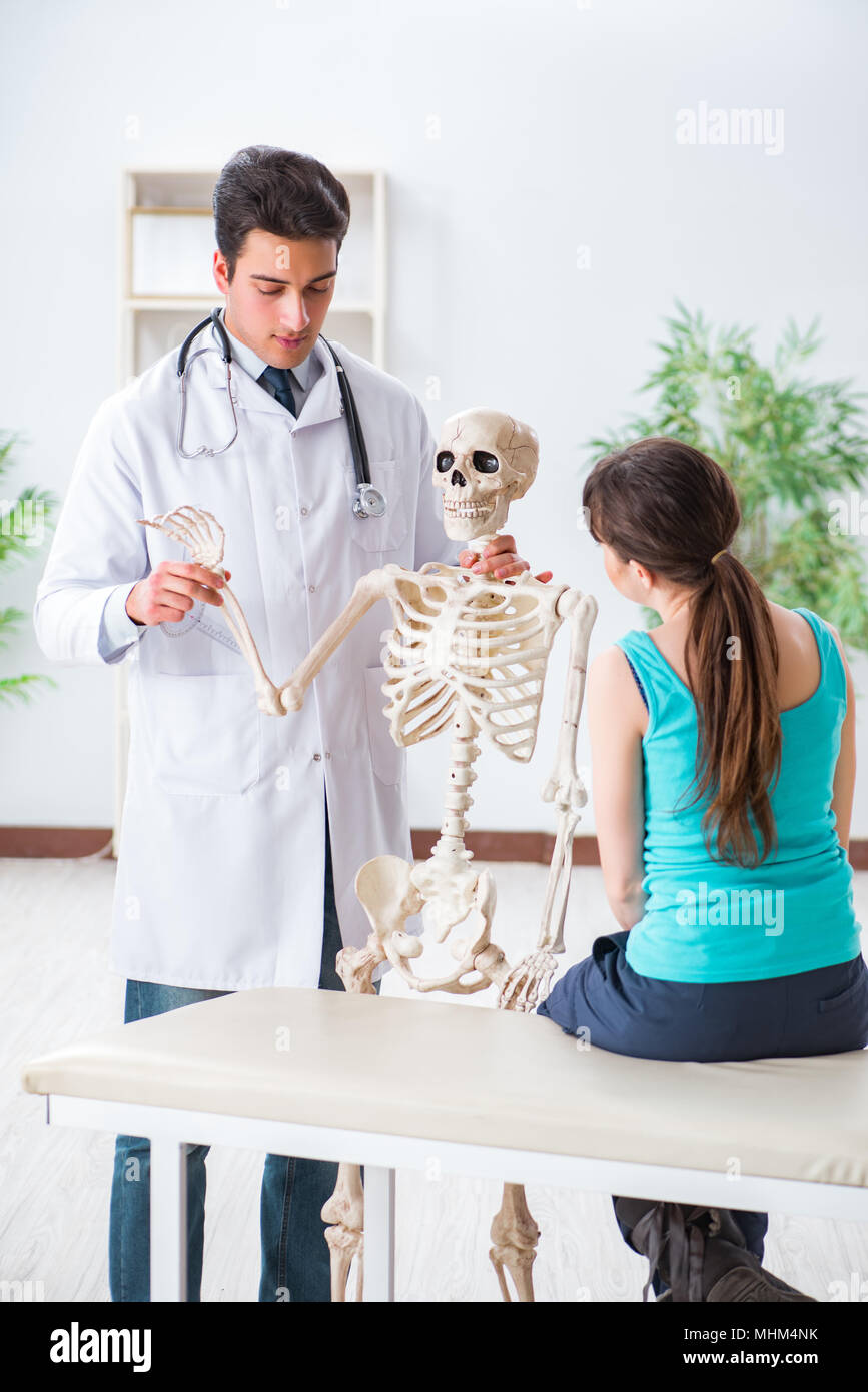Doctor showing type of injury on skeleton to patient Stock Photo - Alamy