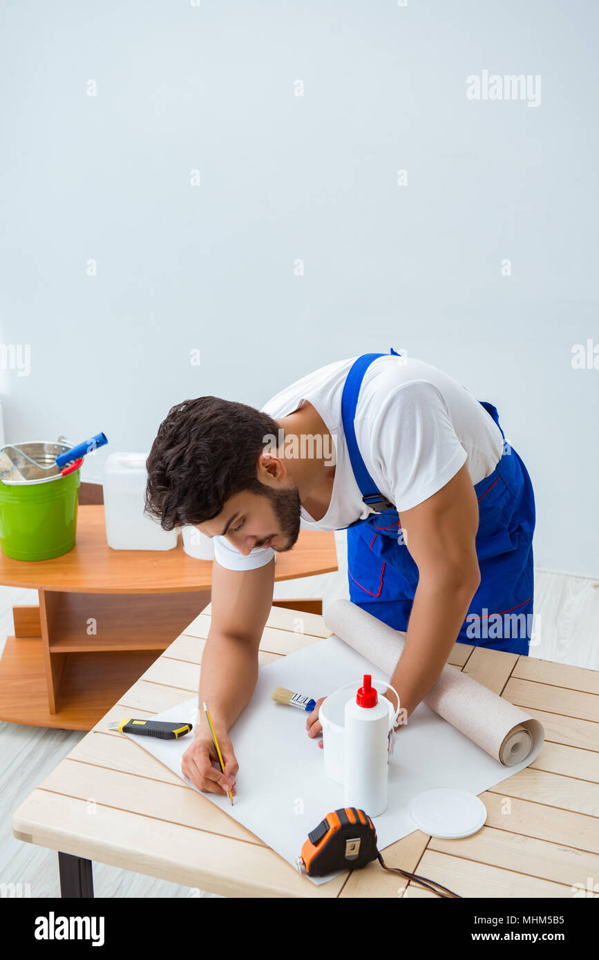 Worker working on wallpaper during refurbishment Stock Photo - Alamy