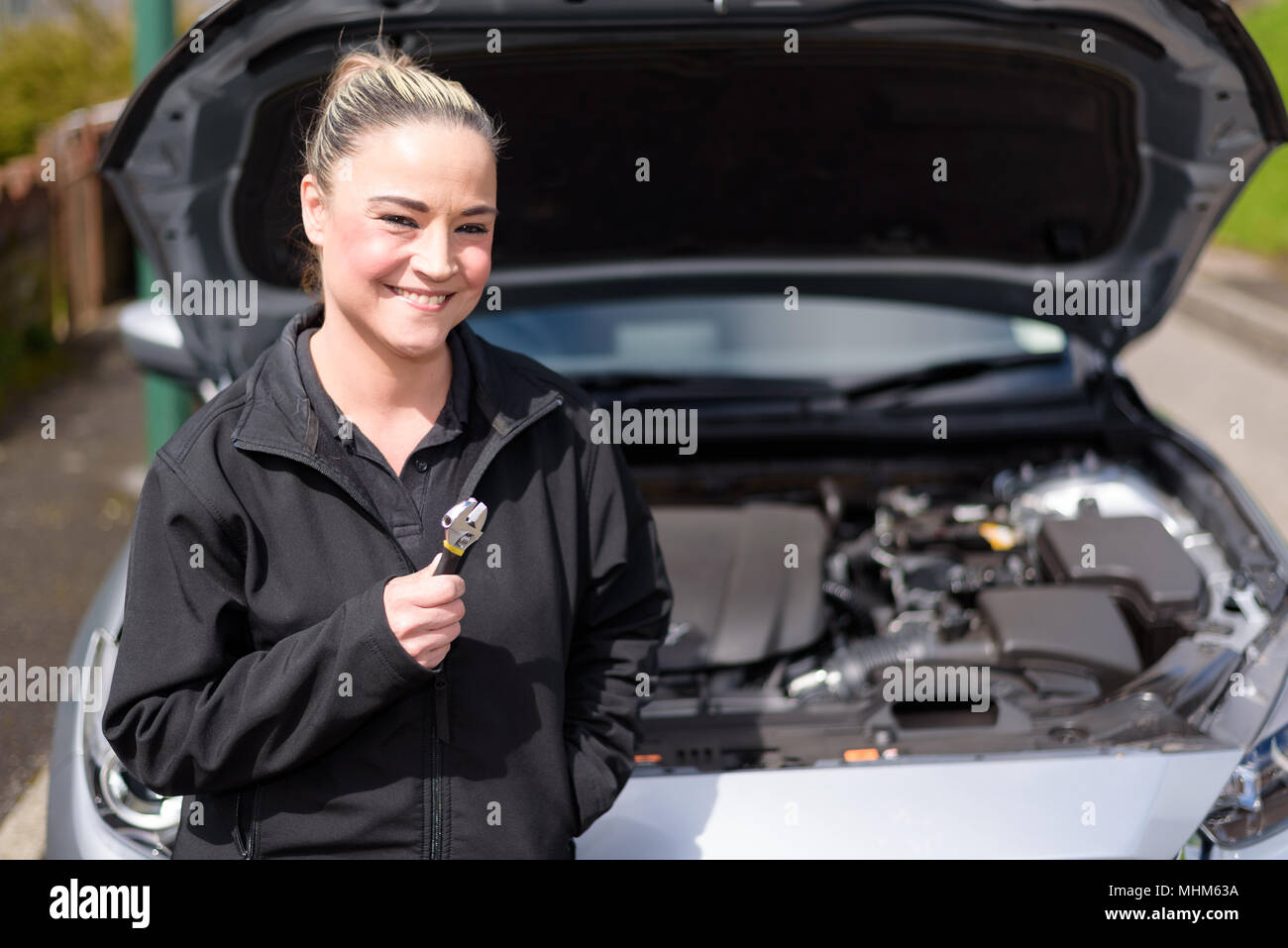 A woman mechanic repairing a car engine at roadside Stock Photo - Alamy