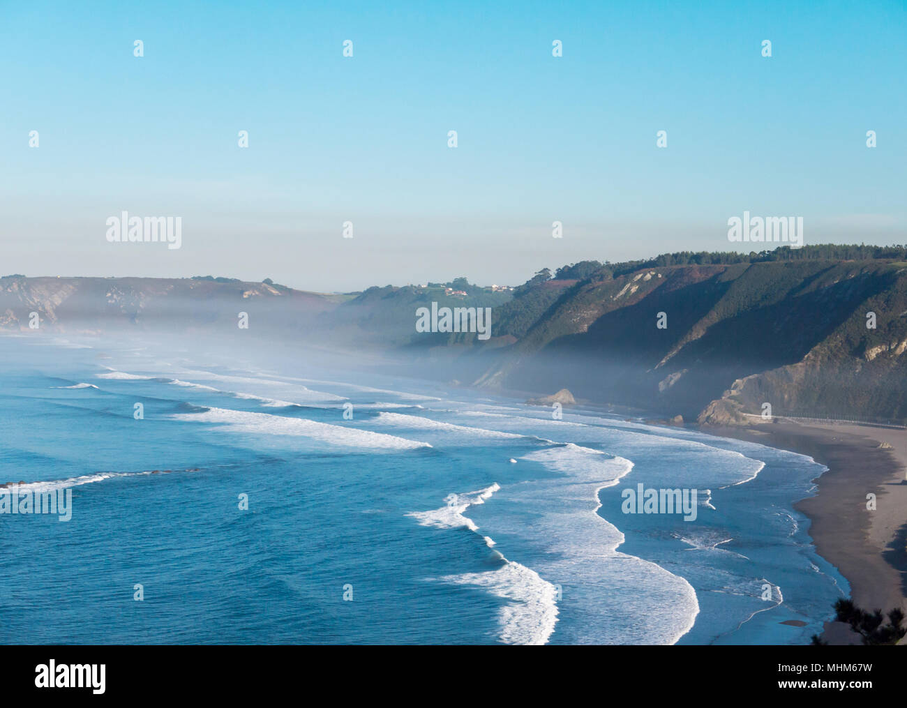 Ocean coast line with large waves covered with water mist Stock Photo ...