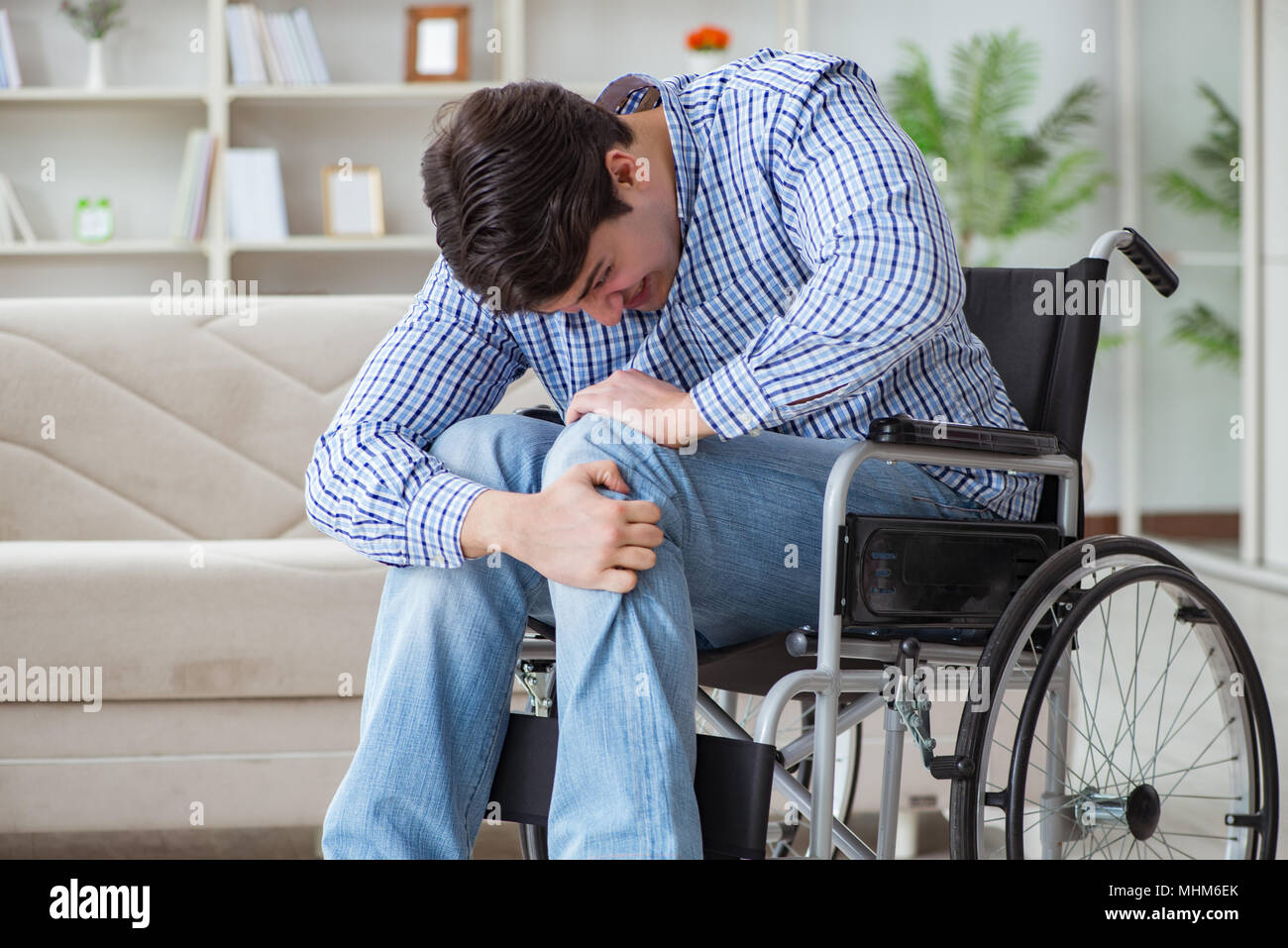 Disabled young man suffering at home Stock Photo - Alamy