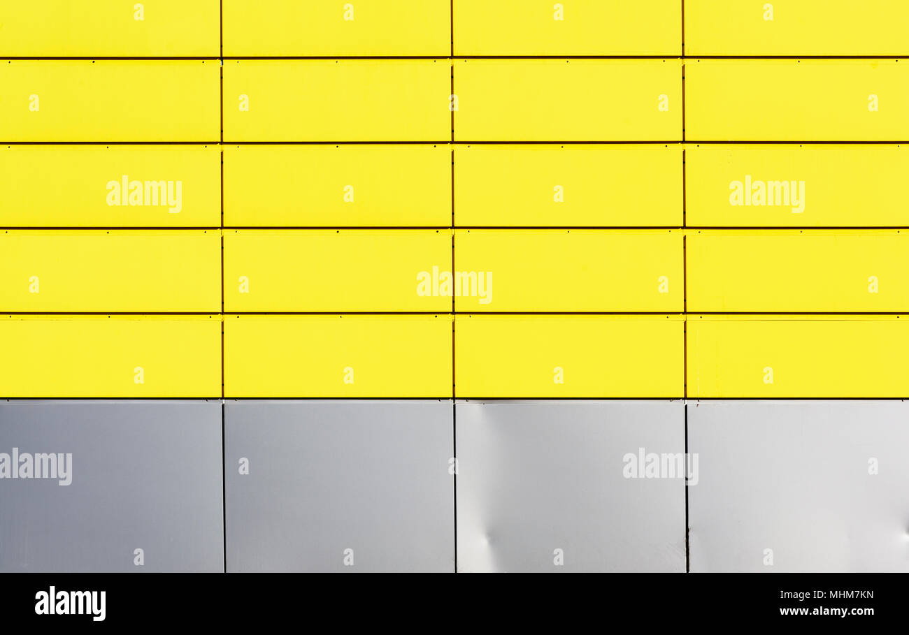 fragment of a yellow and gray iron wall made of rectangular blocks with ...