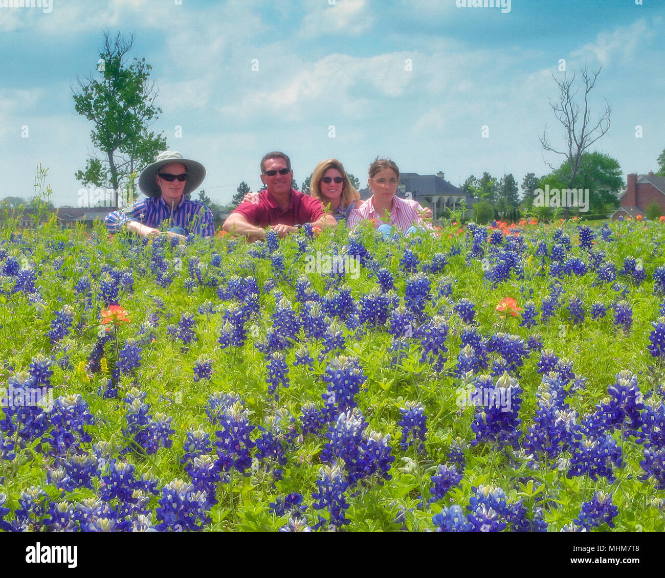 Family enjoying field of bluebonnets and indian paintbrush wildflowers ...