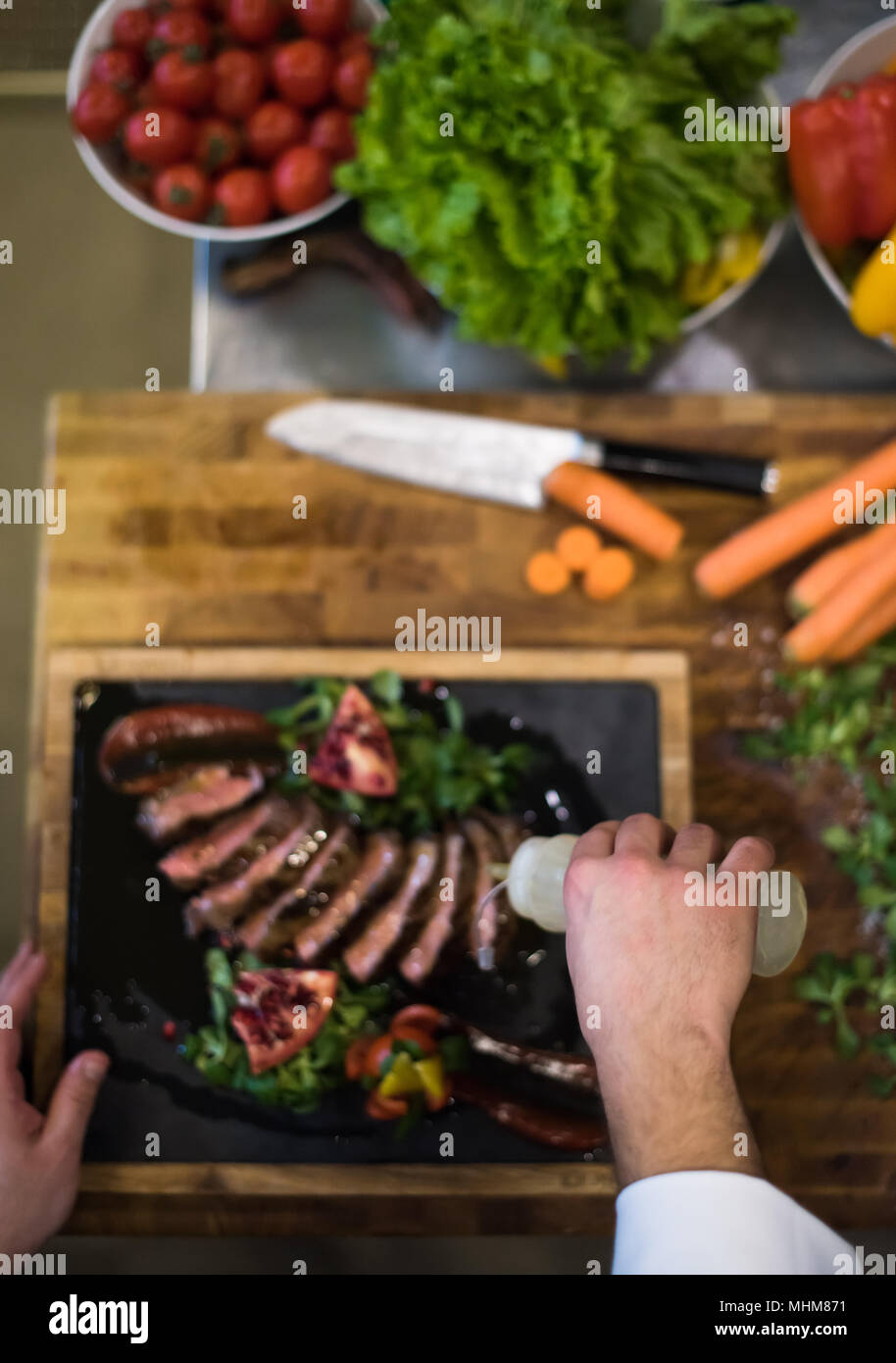 Chef finishing steak meat plate with Finally dish dressing and almost ...