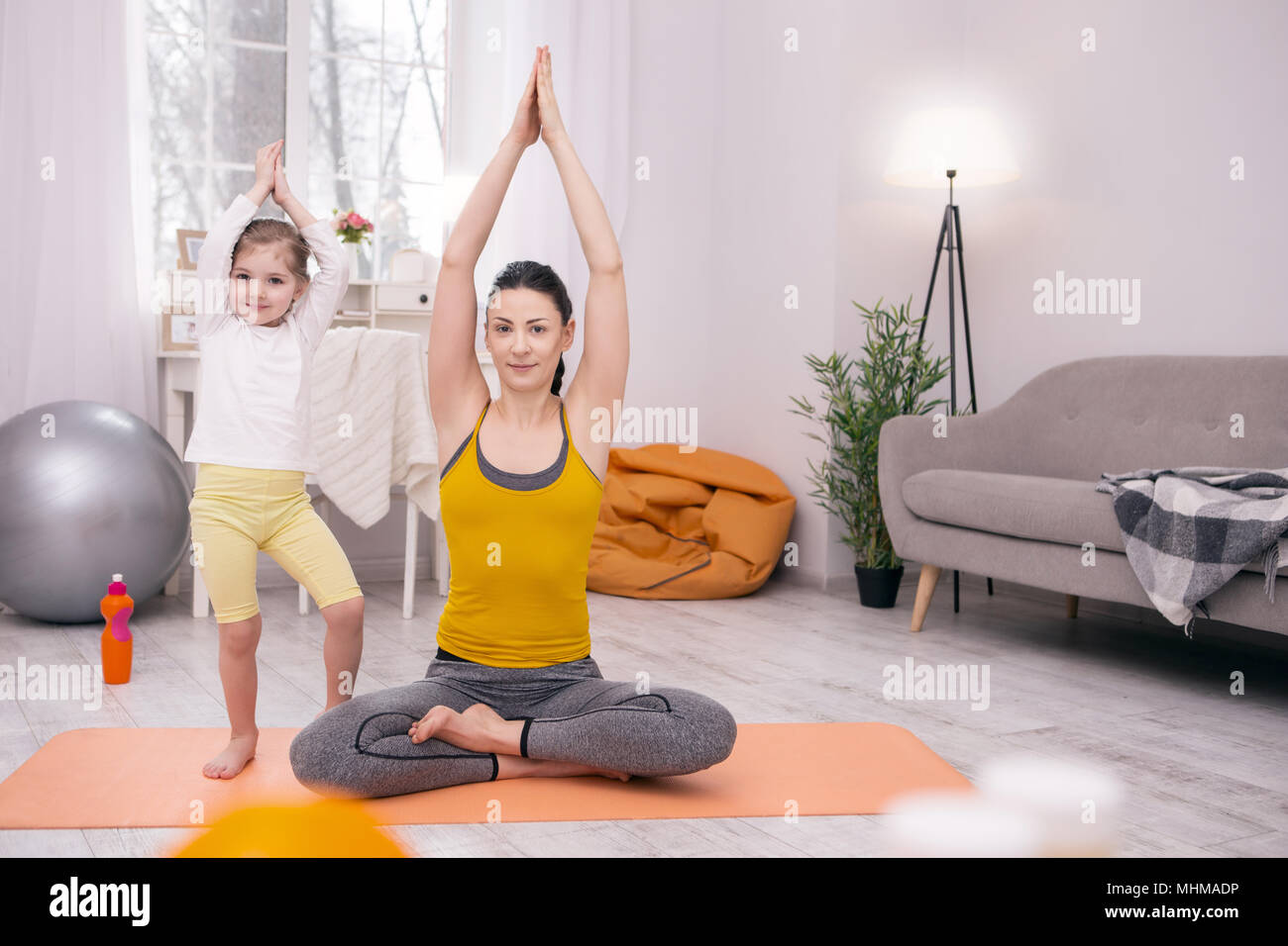Alert mummy doing exercises with her kid Stock Photo - Alamy