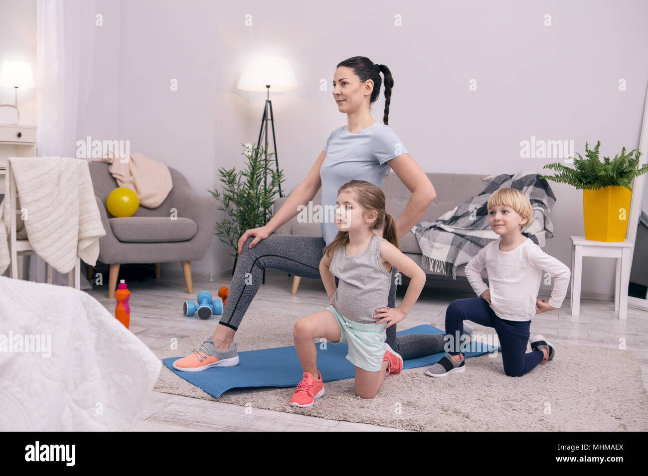 Cheerful mom training with her little kids Stock Photo - Alamy