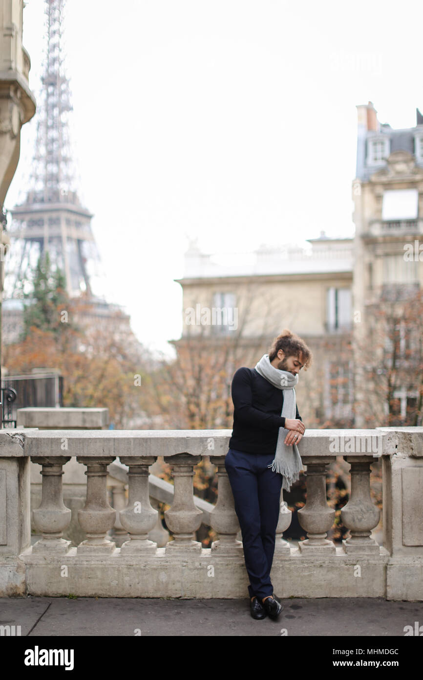 Afro american man standing near concrete railing with Eiffel Tower ...