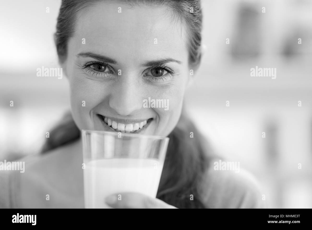 Happy young woman drinking milk Stock Photo - Alamy