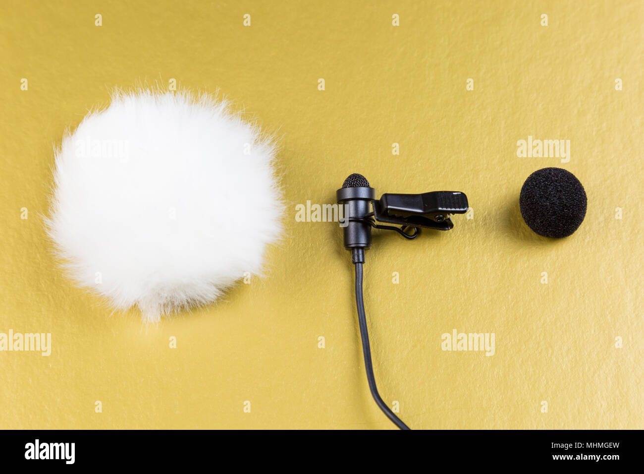 A small microphone for recording quality sound on a gold background ...