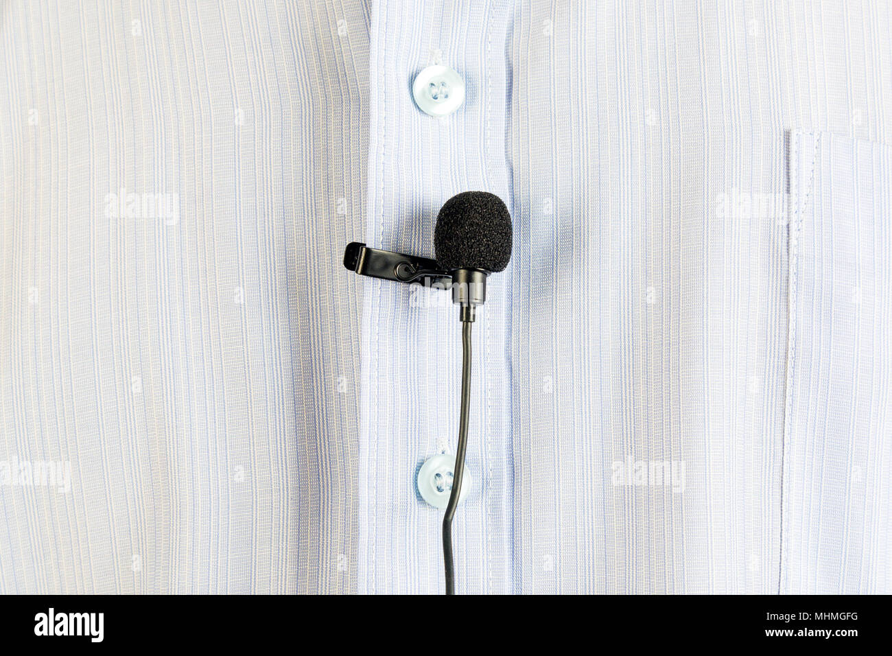 The man fixed the mini microphone to his blue shirt Stock Photo - Alamy