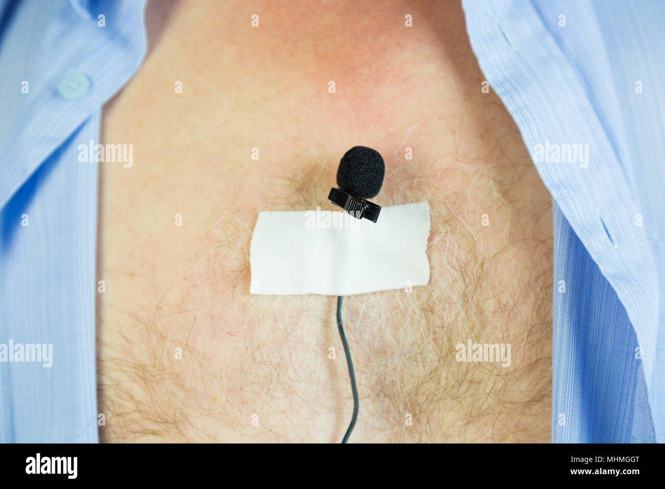 A private detective puts on a small microphone a buttonhole under his ...