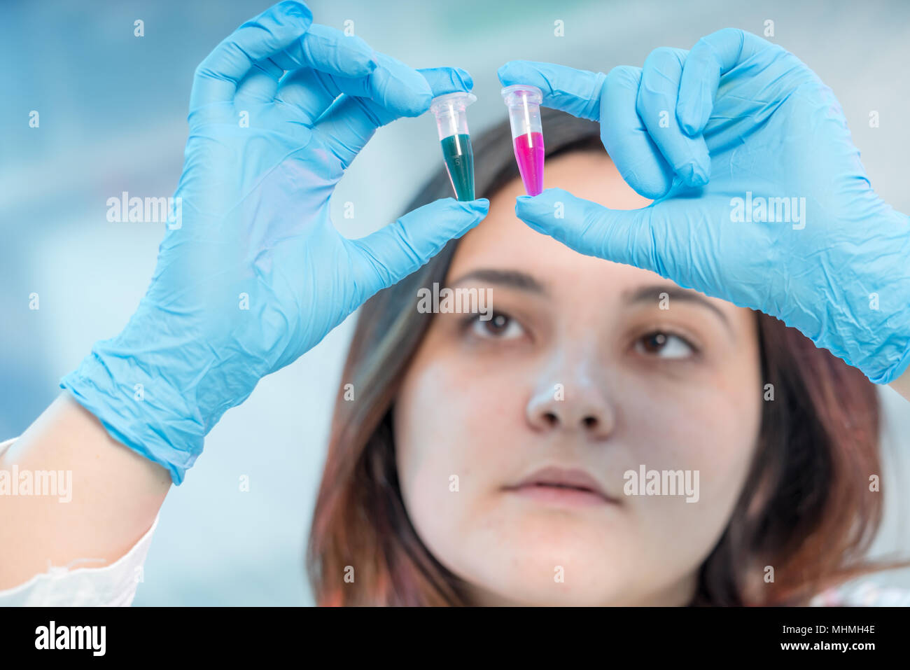 Female medical worker compares test tubes with biological samples Stock ...