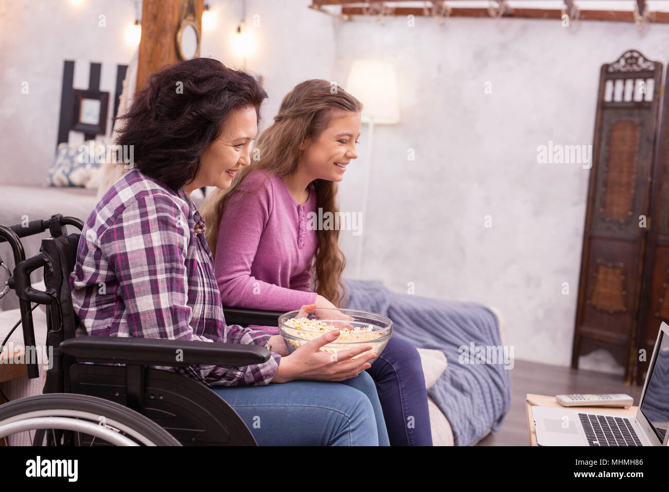 Positive incapacitated woman and girl seeing movie Stock Photo - Alamy