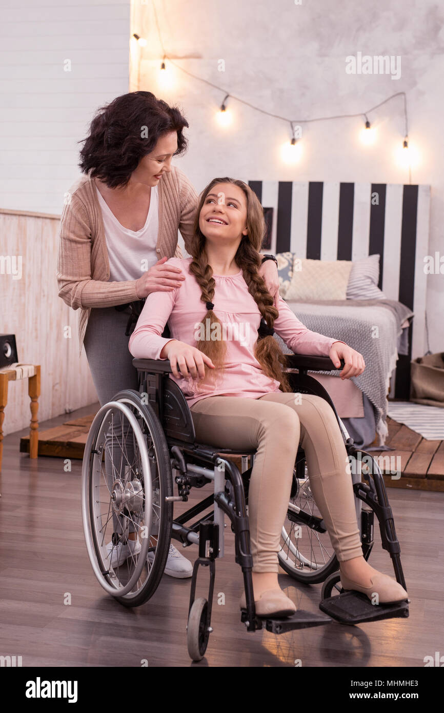 Happy woman taking care of disabled girl Stock Photo - Alamy