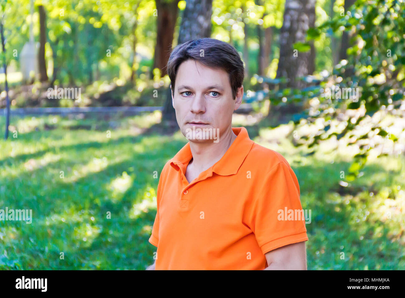 Horizontal portrait of man in orange on green background Stock Photo ...