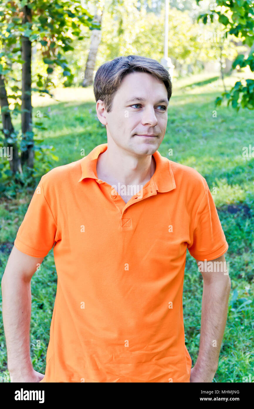 Vertical portrait of man in orange on green background Stock Photo - Alamy