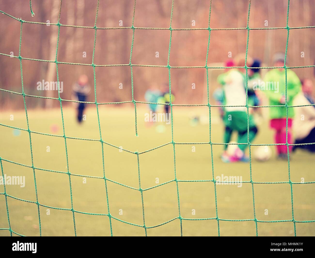 Football player stands against goal with net and stadium. Football gate ...