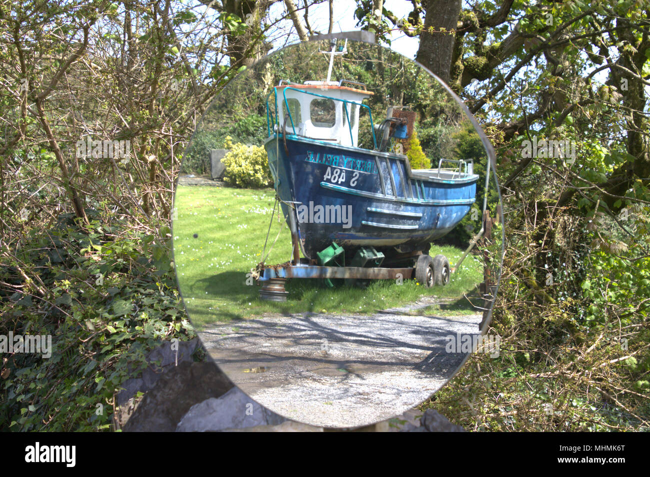 driveway safety mirror reflecting a fishing boat on its trailer Stock ...