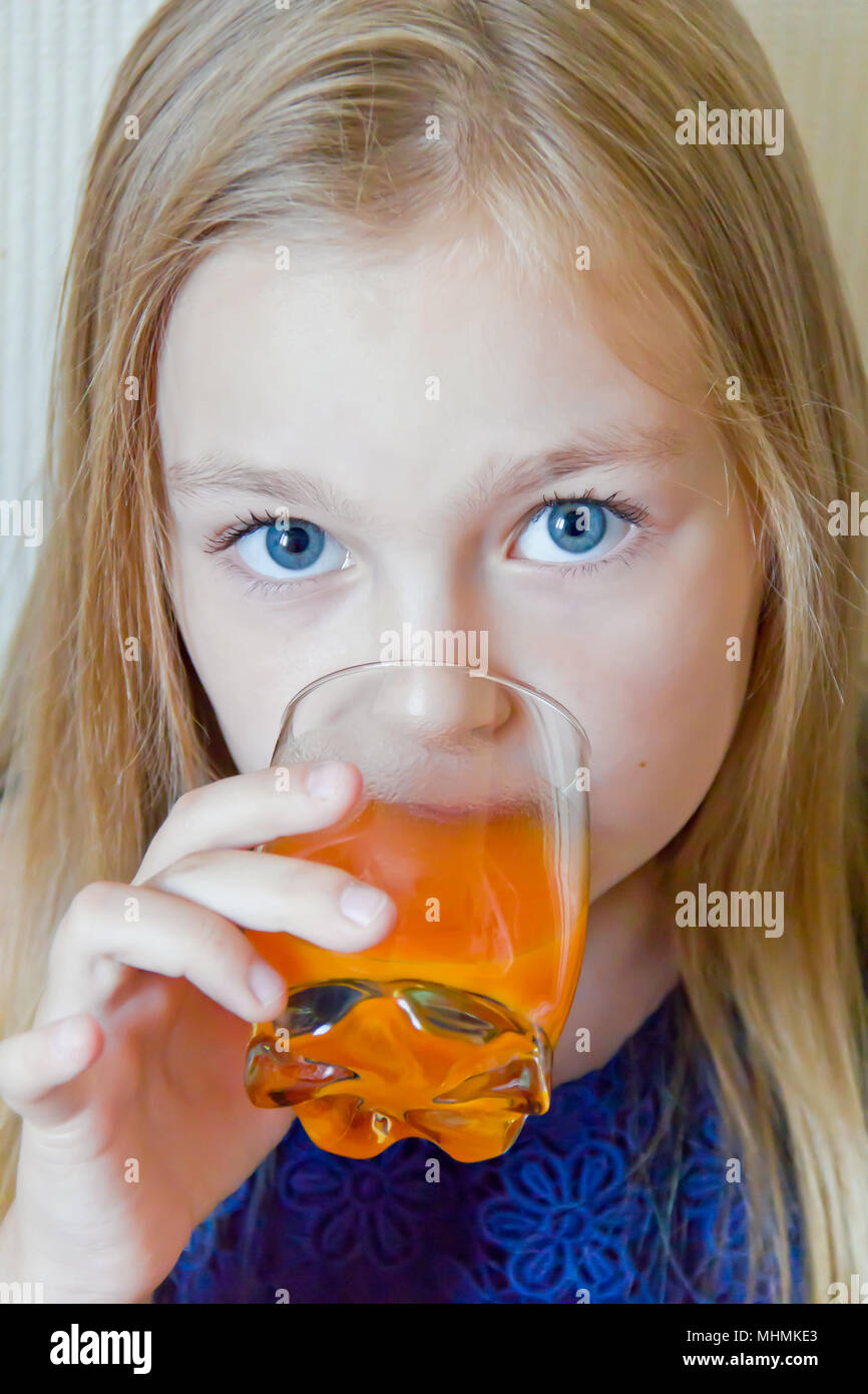 Cute girl with blond long hair drinking beverage Stock Photo - Alamy