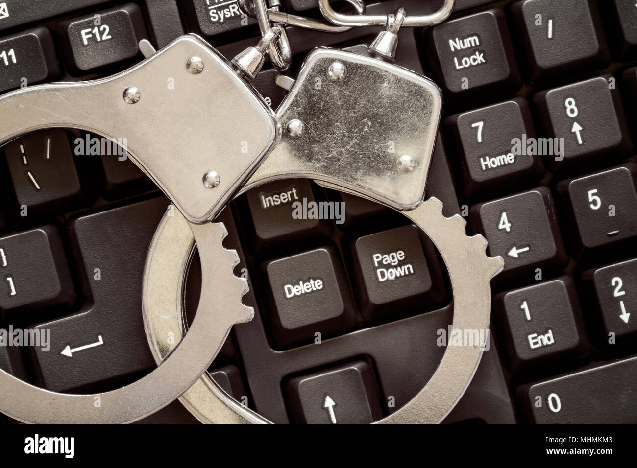 Online crime concept with handcuffs on computer keyboard Stock Photo ...
