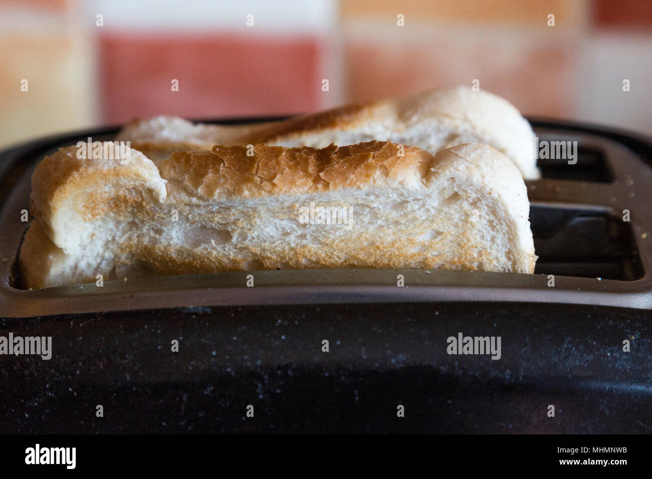 Two slices of toast in toaster Stock Photo - Alamy
