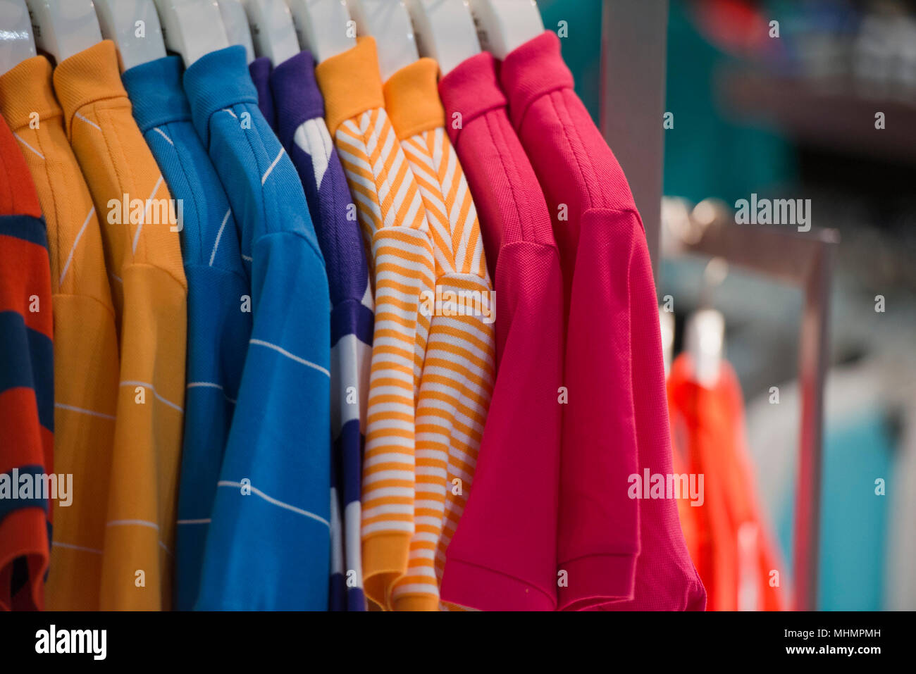 different colors polo shirt on display stand Stock Photo - Alamy