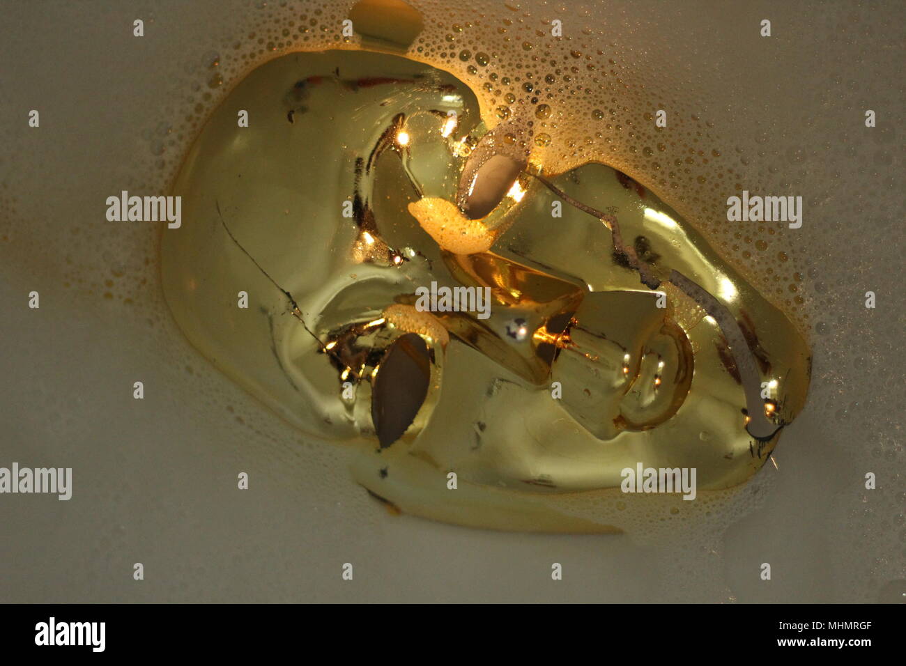Abstracts & Backgrounds conceptual art - Gold coloured plastic face ...