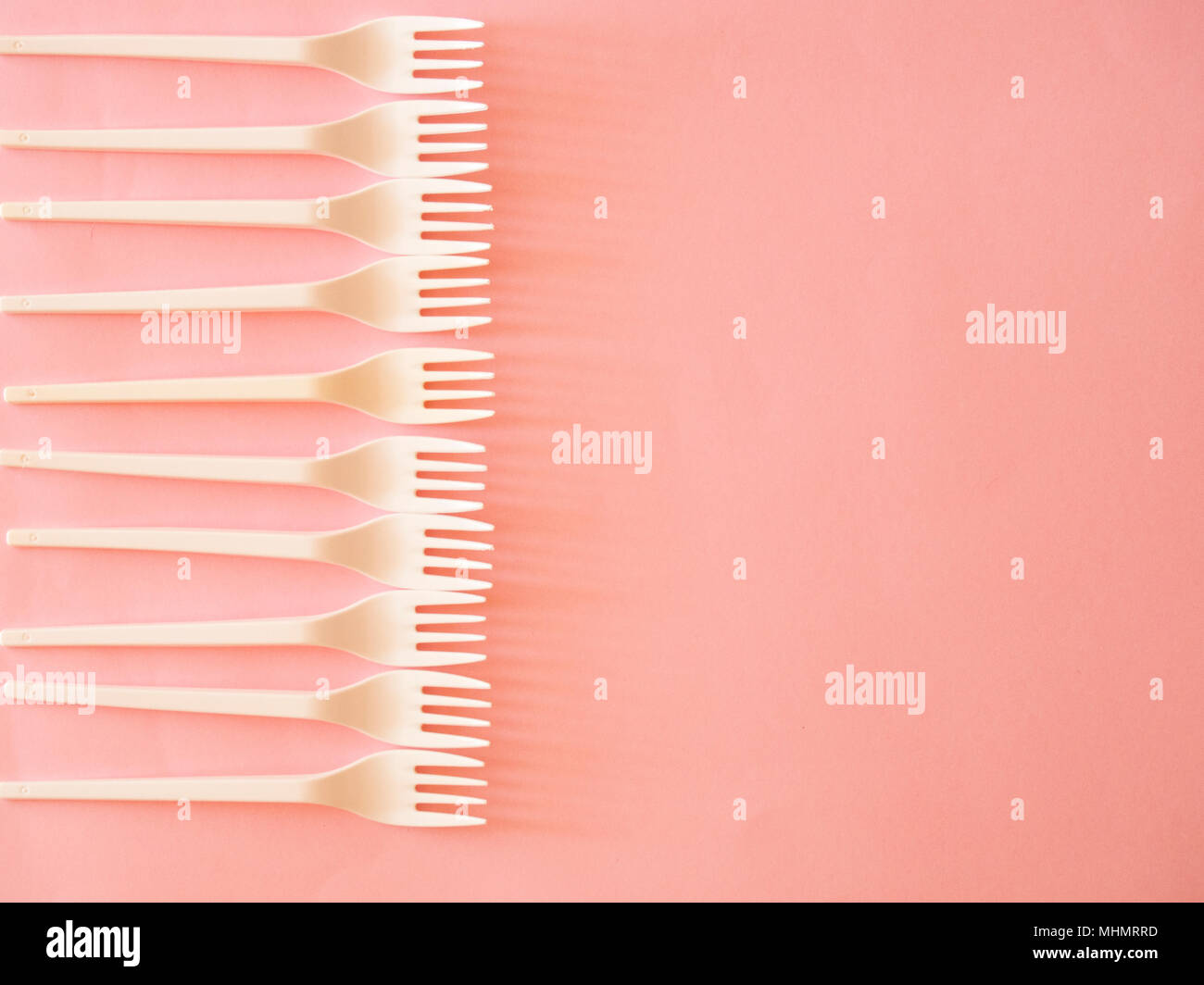 Plastic fork pattern on pink background Stock Photo - Alamy