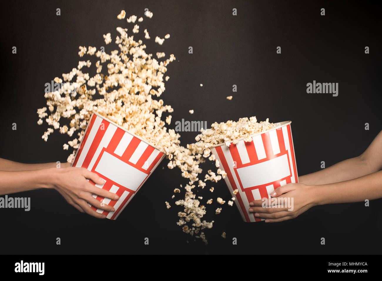 people spilling out popcorn from buckets Stock Photo - Alamy