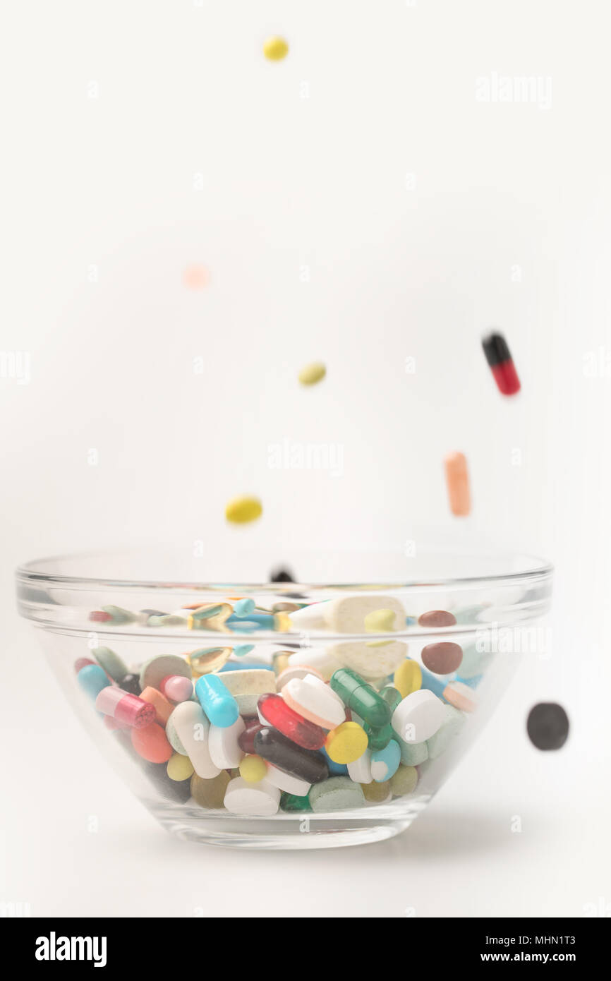 Pills falling into glass bowl Stock Photo - Alamy