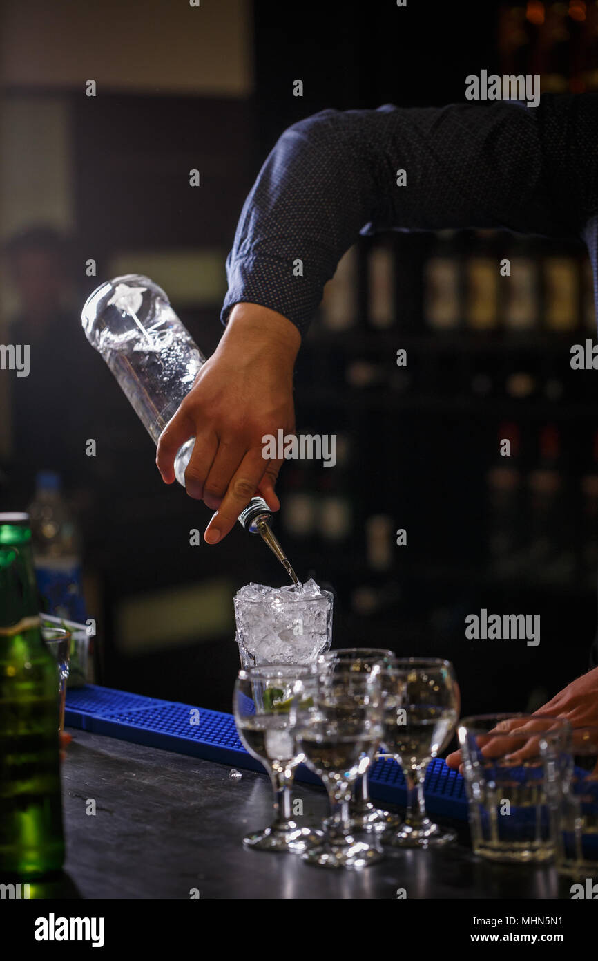 Bartender pours syrup in cocktail glass at a bar counter Stock Photo ...
