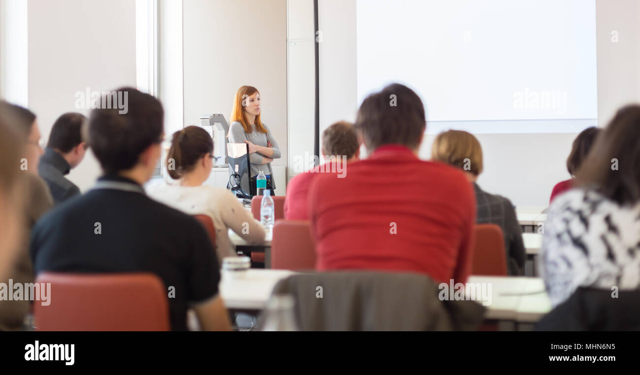 Woman giving presentation in lecture hall at university Stock Photo - Alamy
