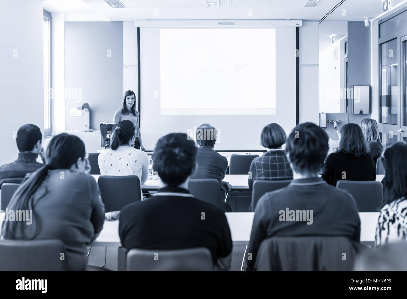Woman giving presentation in lecture hall at university Stock Photo - Alamy