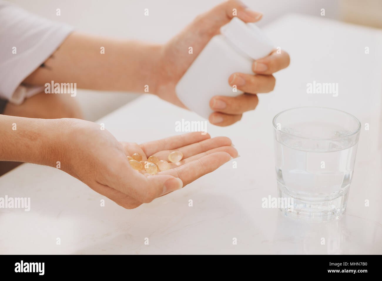 Person takes yellow pills capsule hi-res stock photography and images ...