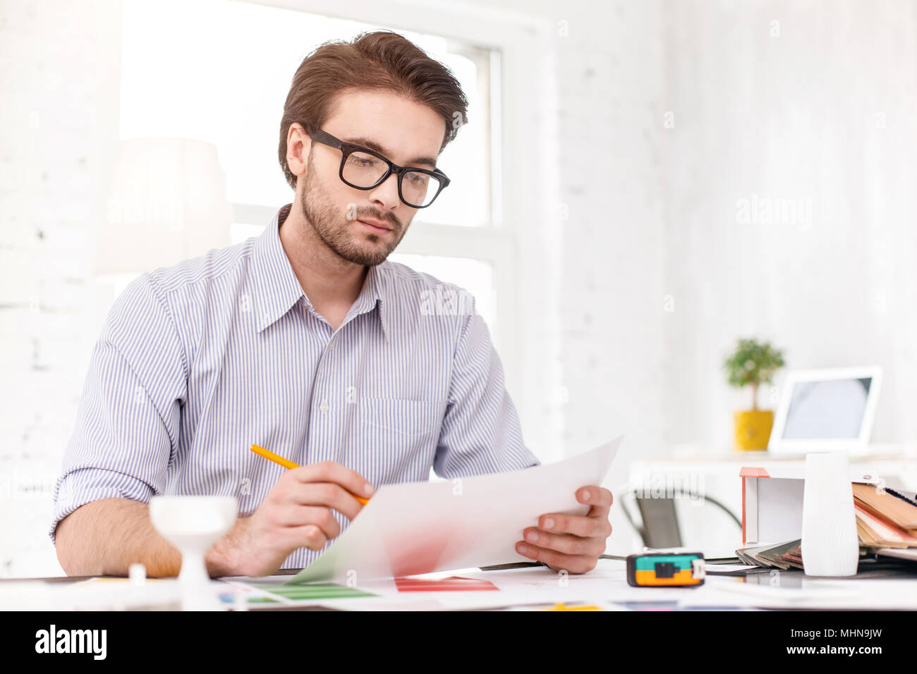 Concentrated employee holding a sheet of paper Stock Photo - Alamy