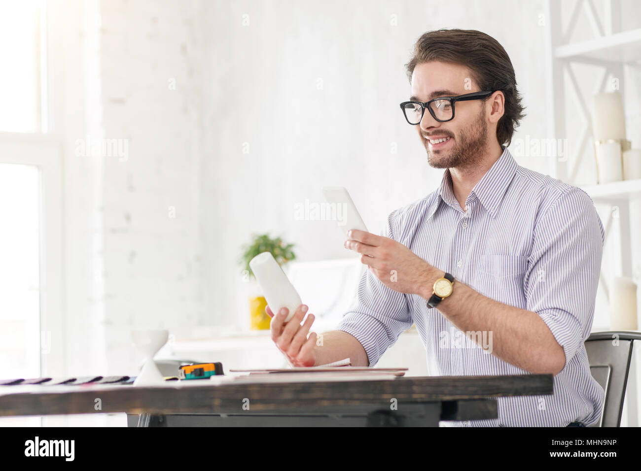 Joyful man taking pictures of a white object Stock Photo - Alamy