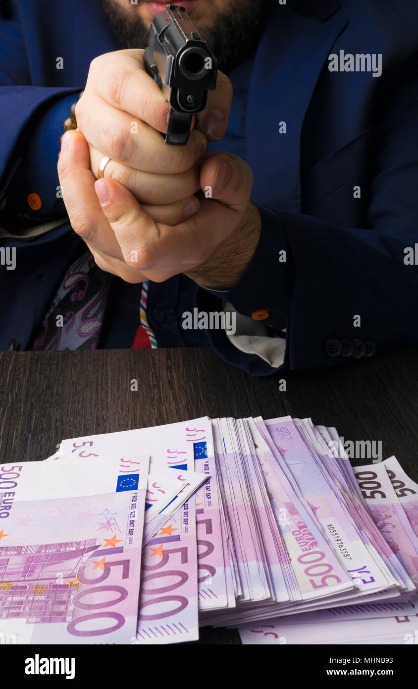 A man in blue suit with a gun directed. Cash, hundreds of euros aducted ...