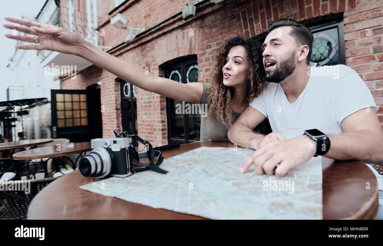Young tourists drinking coffee at cafe and reading city map Stock Photo ...