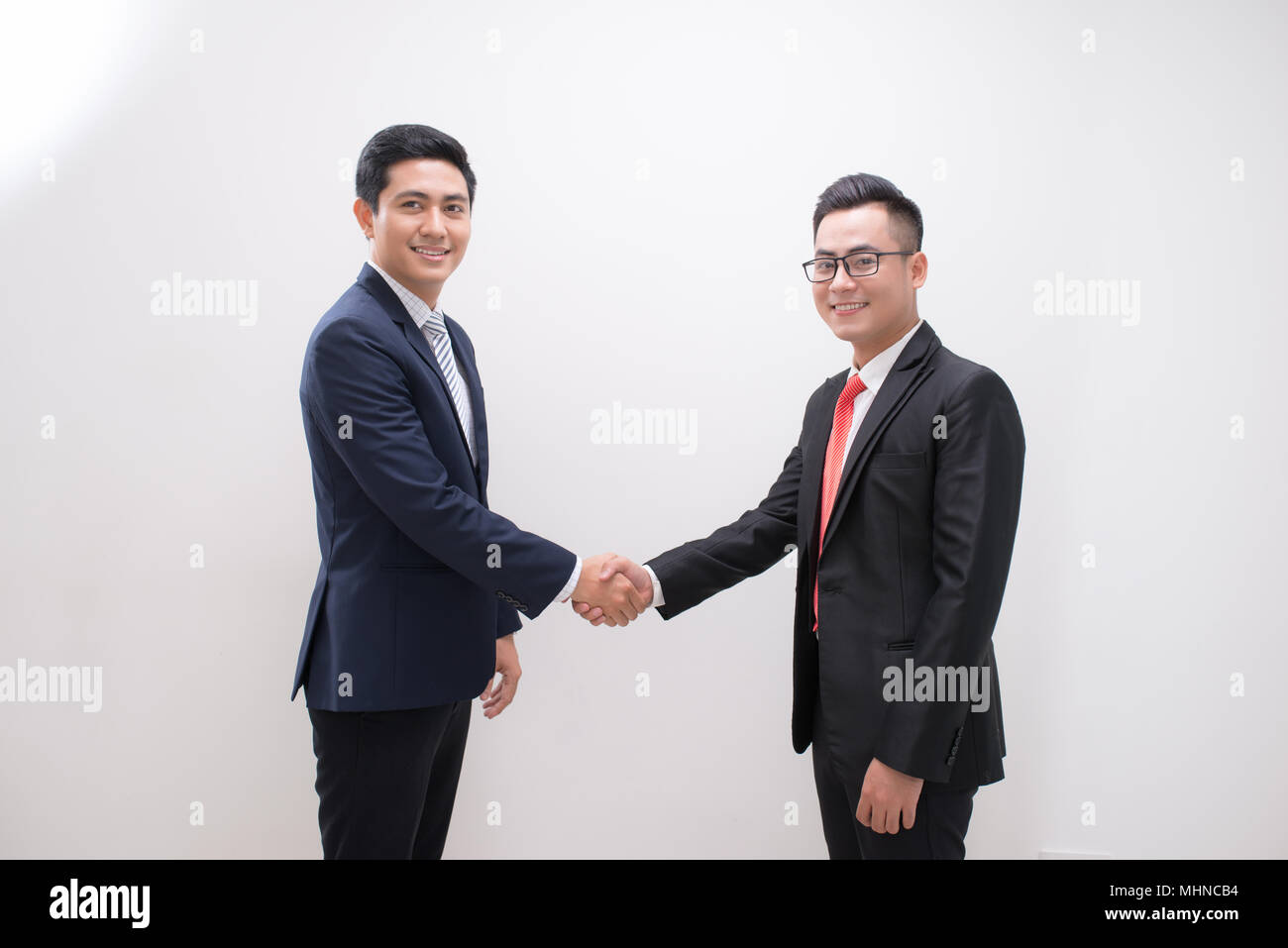 Two young men shaking hands hi-res stock photography and images - Alamy