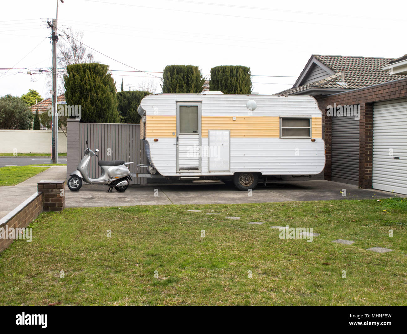 A fun picture of a scooter placed in front of a caravan Stock Photo - Alamy